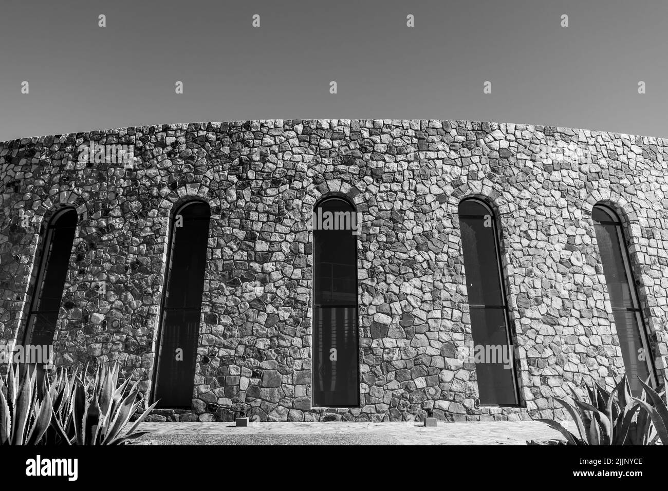 A grayscale shot of a stone building with big windows Stock Photo - Alamy