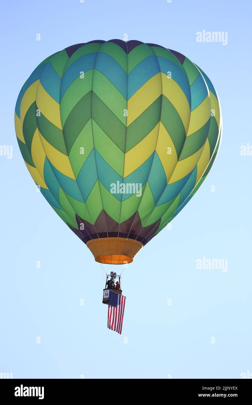 A vertical shot of an air balloon waving the American flag in the air ...