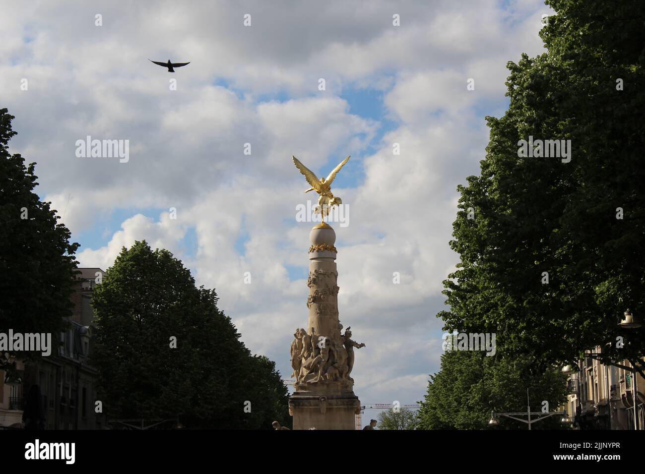 a gold angel statue on top of a building with a cloudy blue sky in the ...