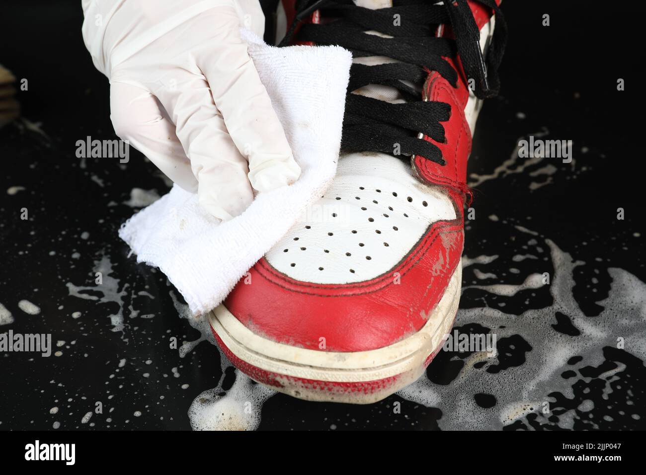 A red nike air force is being scrubbed by soap by a brush Stock Photo ...