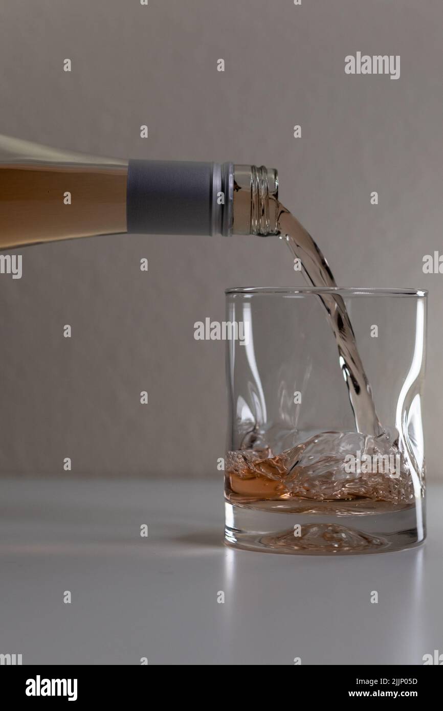 A vertical shot of an alcoholic drink being poured into a glass Stock ...