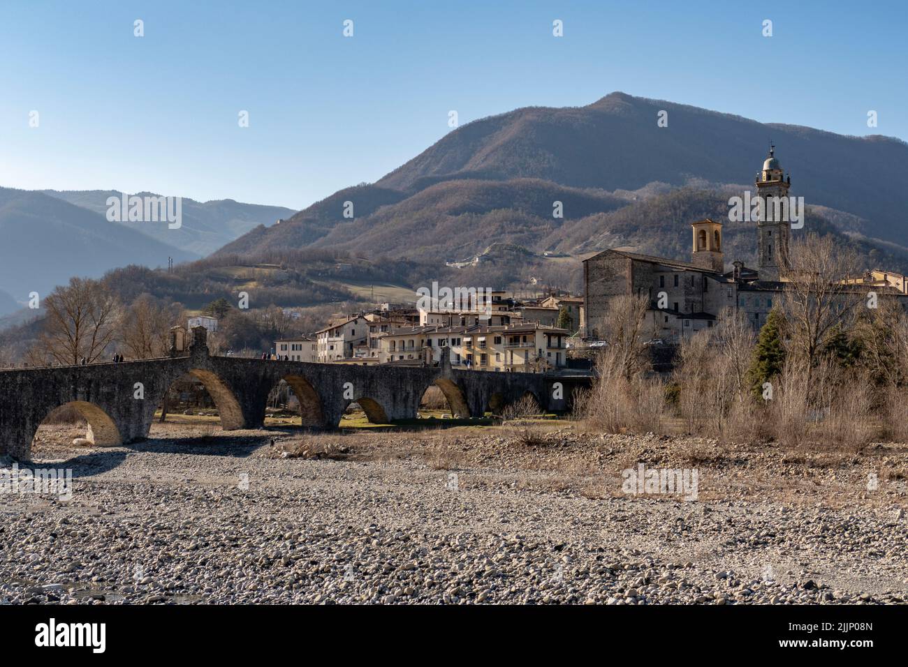 The Ponte Gobbo bridge with ancient buildings surrounded by mountains ...