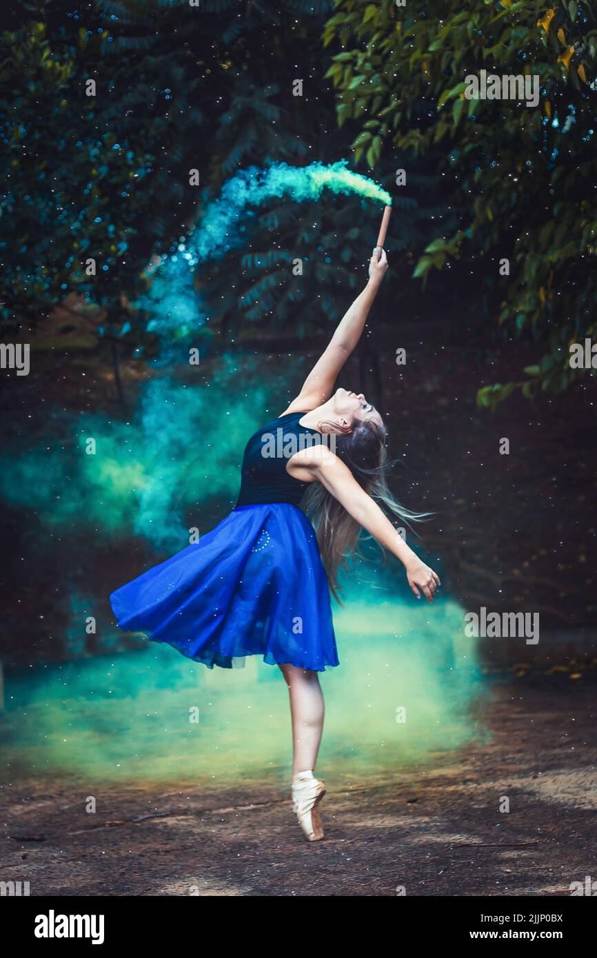 A beautiful young ballerina with a blue colored smoke bomb Stock Photo ...