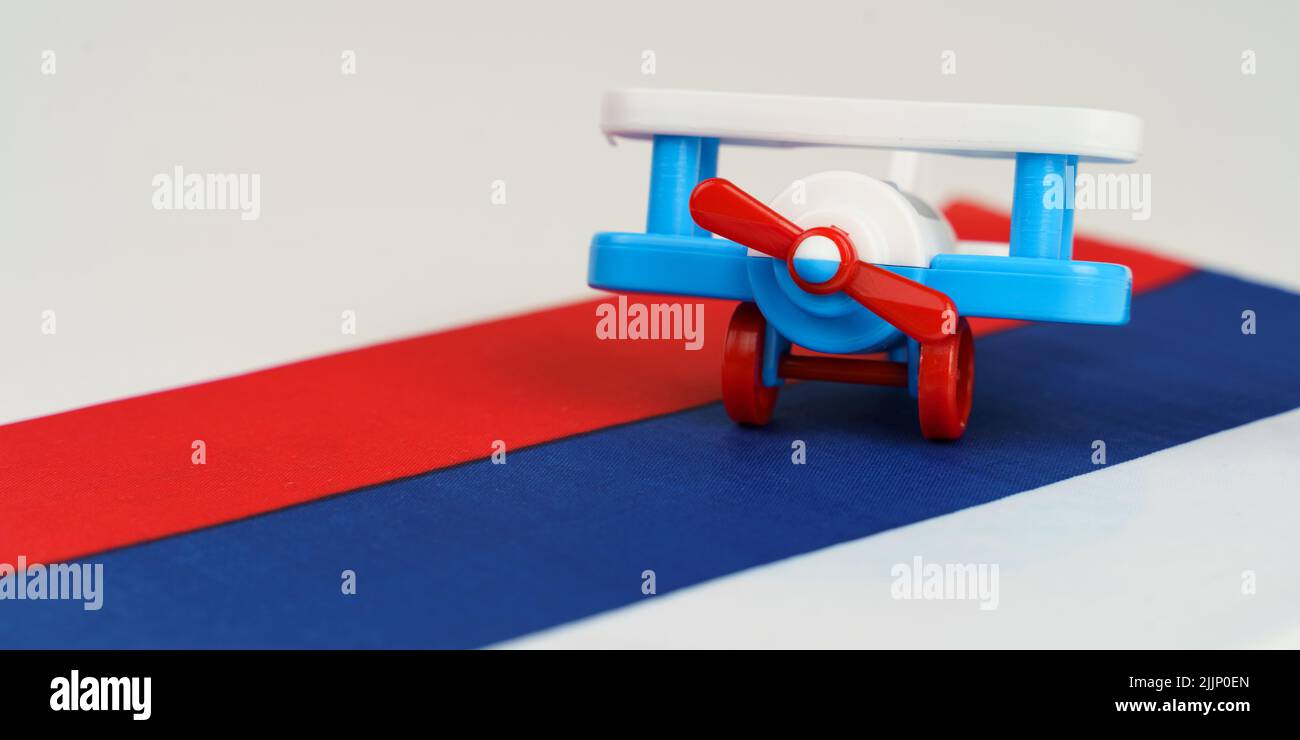 A toy plane stands on the flag of Russia. Travel and business concept ...