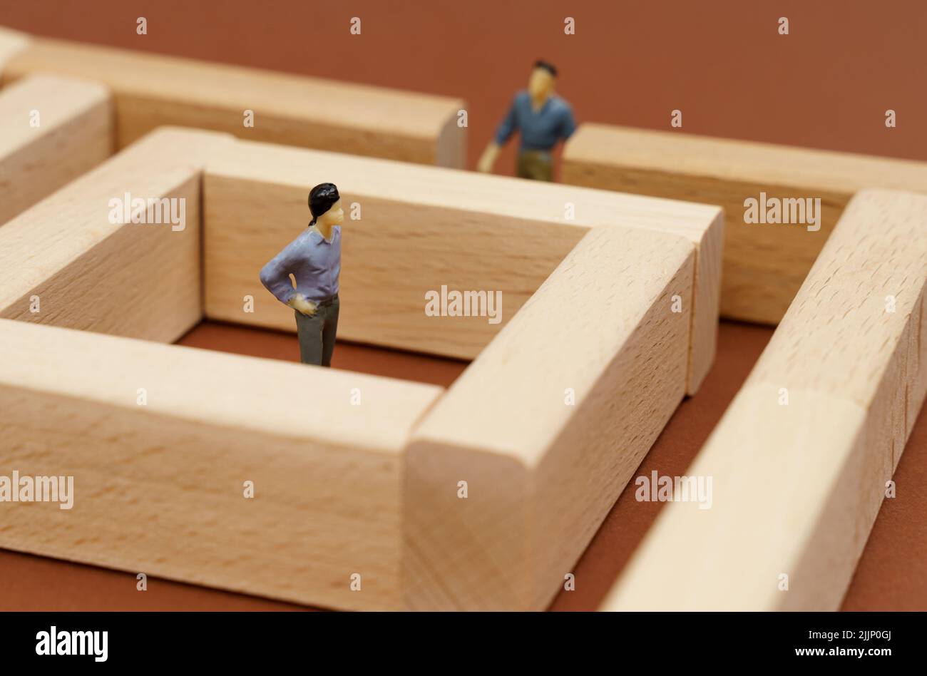 Wooden blocks on a brown surface. In blocks, a person is isolated from ...
