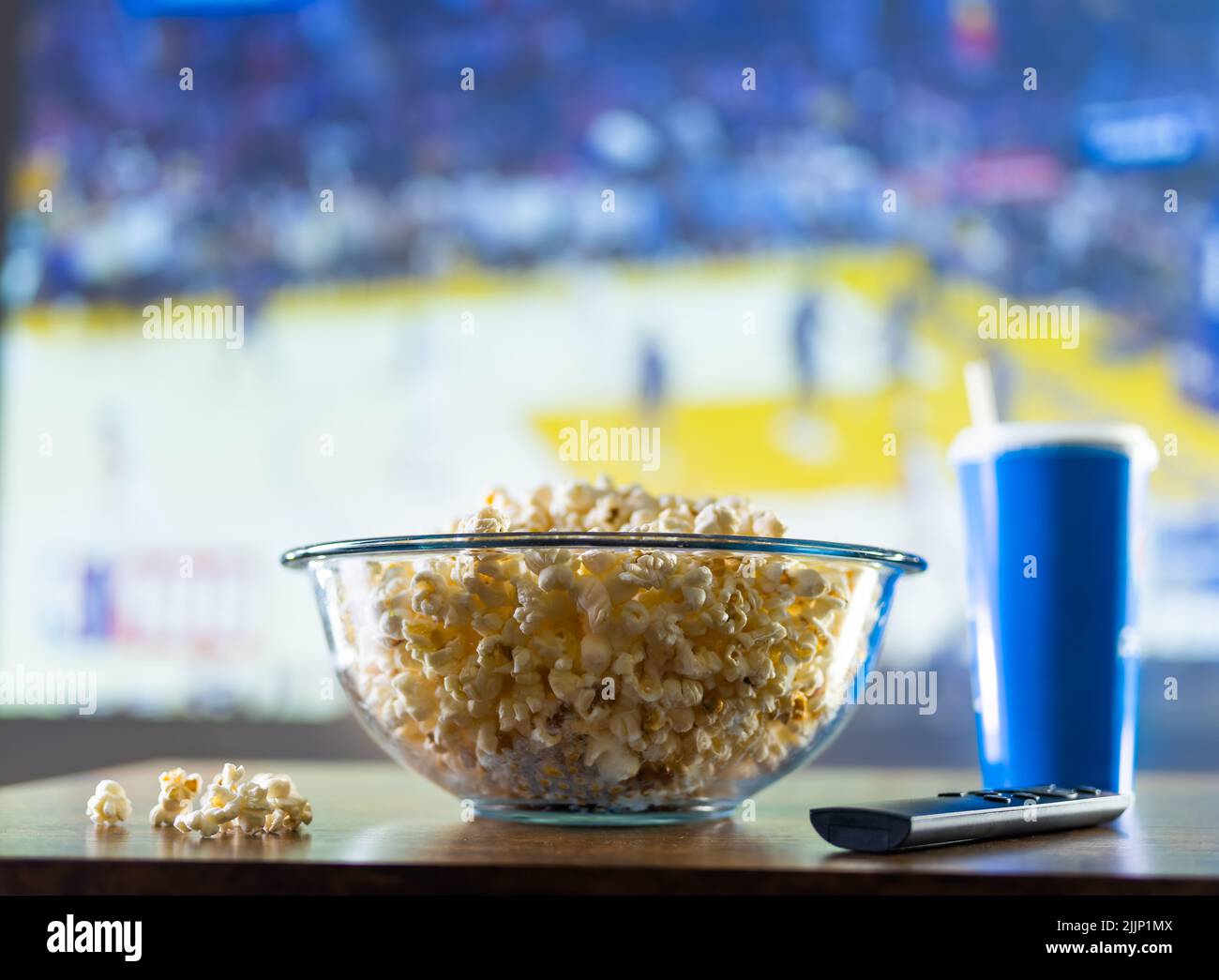 The traditional set of a sports fan is a large glass bowl of popcorn, a ...