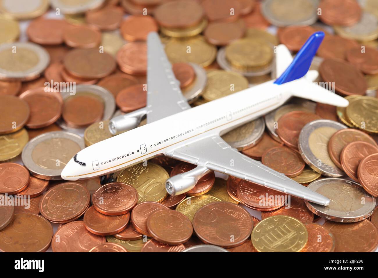 A plane toy on euro coins isolated on a white background - save money ...
