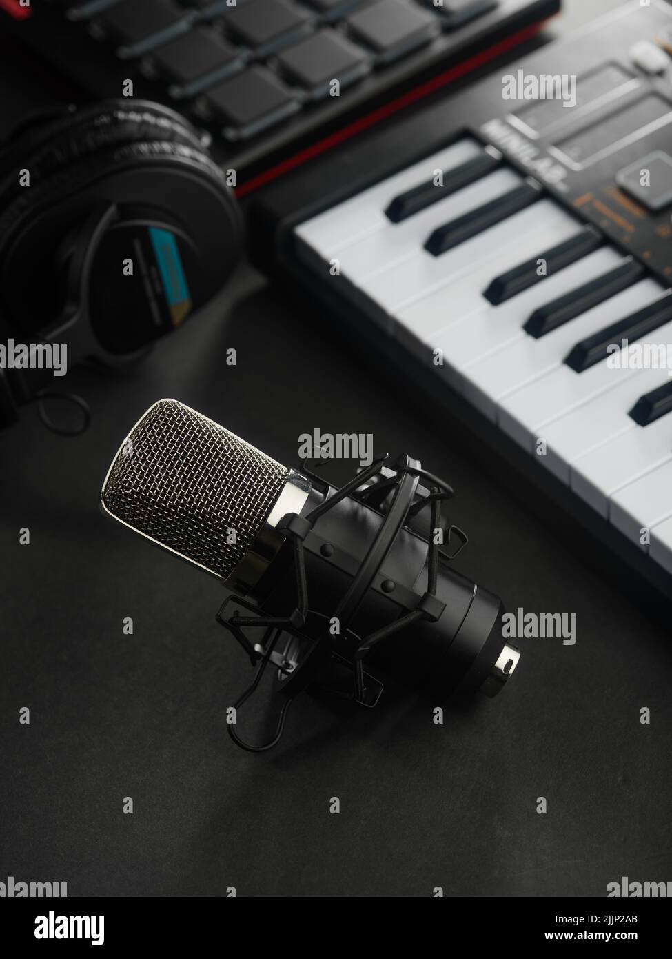 On a dark gray background, a midi keyboard, studio microphone, studio ...