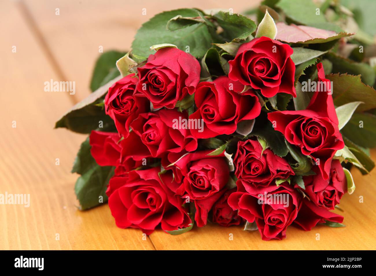 A beautiful bouquet of red roses on a wooden laminated floor Stock ...