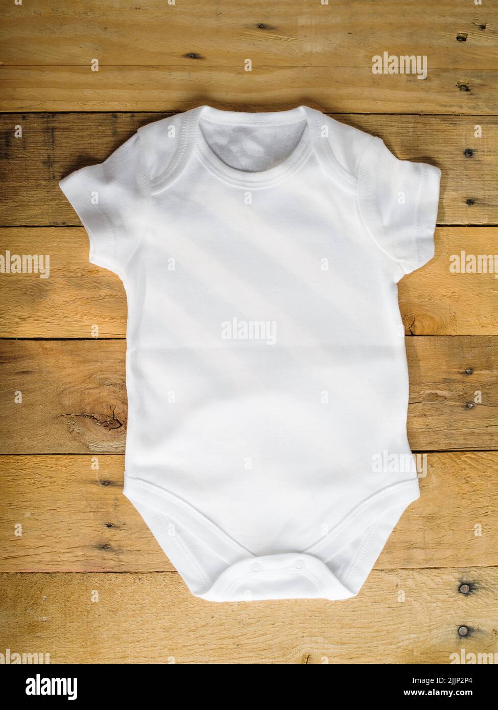 Flat lay of a white baby bodysuit for newborn boys and girls made of ...