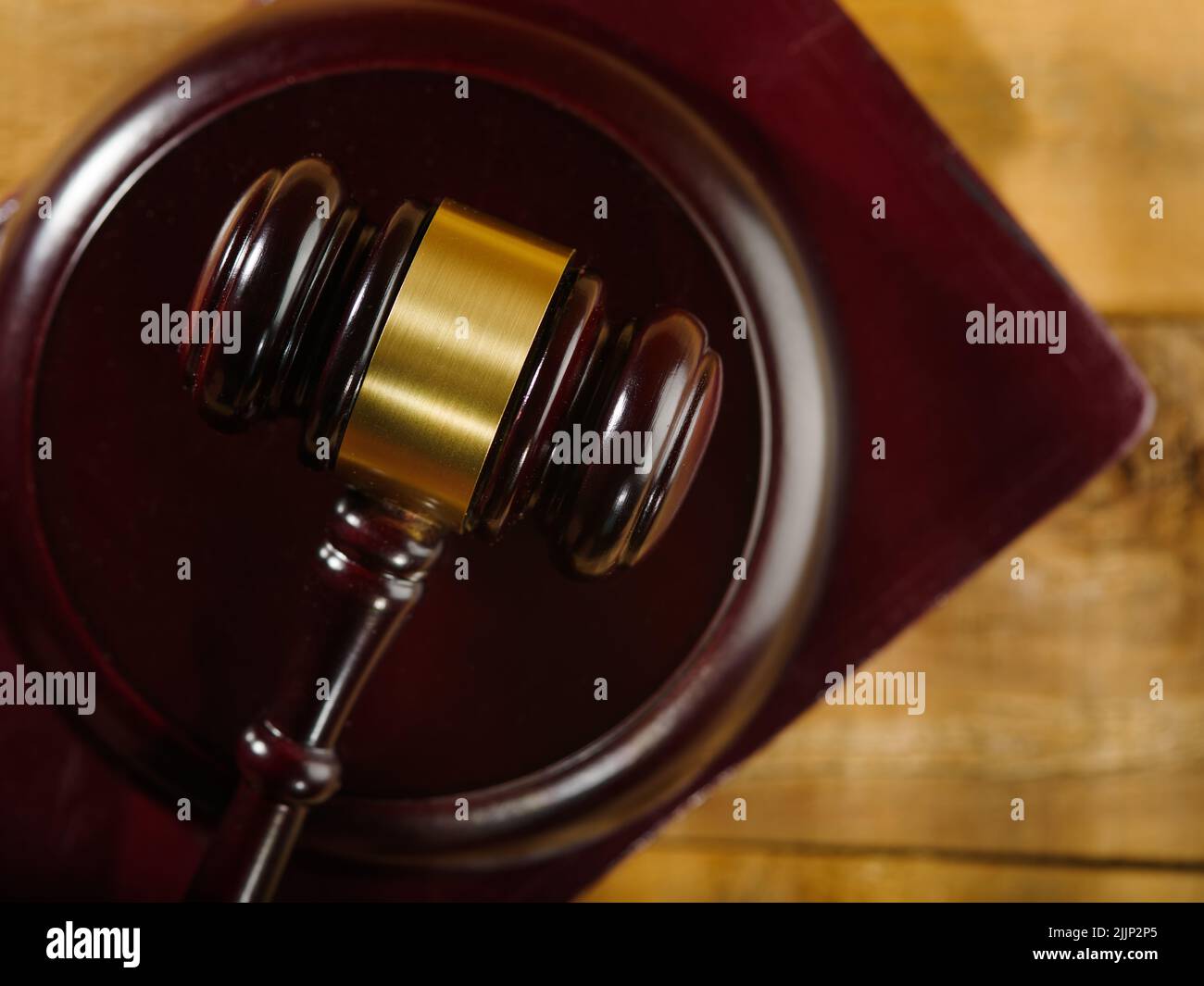 Macro shot. Mahogany judge's gavel. Isolated on a wooden background. A ...