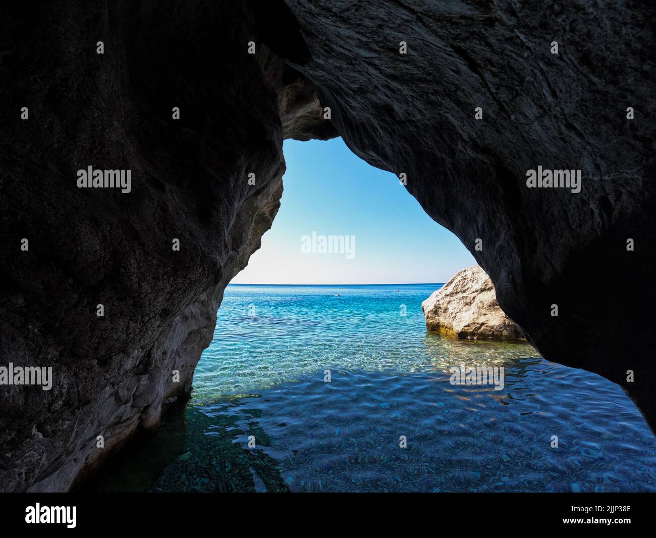 View from inside a cave to a beautiful ocean and a rock structure Stock ...