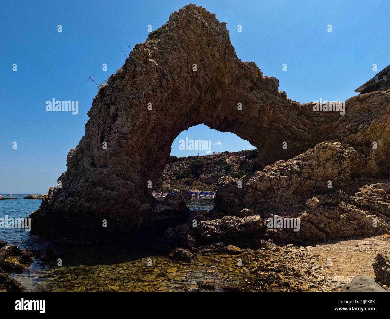 Interesting rock structure hole on Stegna beach Stock Photo - Alamy