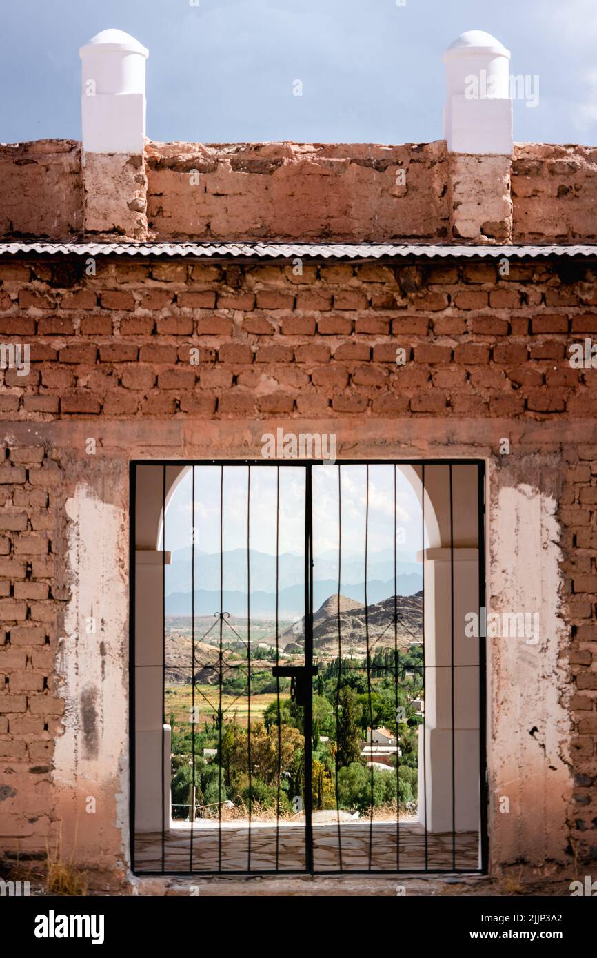 A view of a brick wall with an iron gate Stock Photo - Alamy
