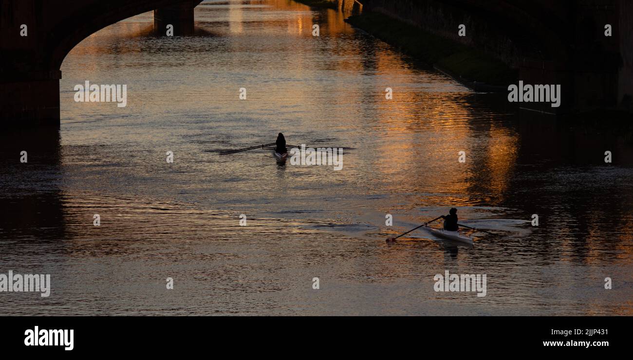 A beautiful shot of two sailors on the water surface in Florence, Italy ...