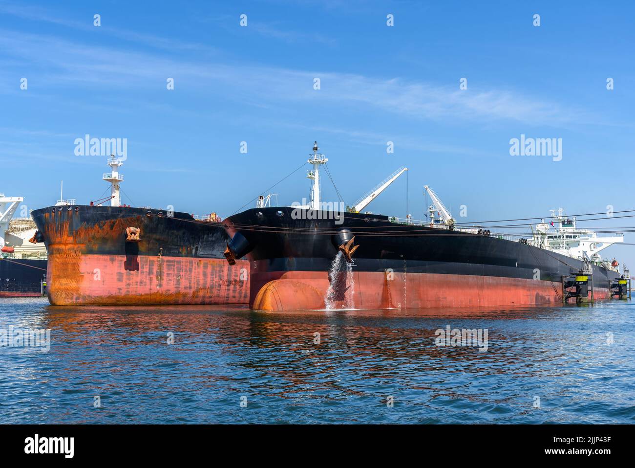 Two large crude oil tanker ships in a harbour on a clear summer day ...