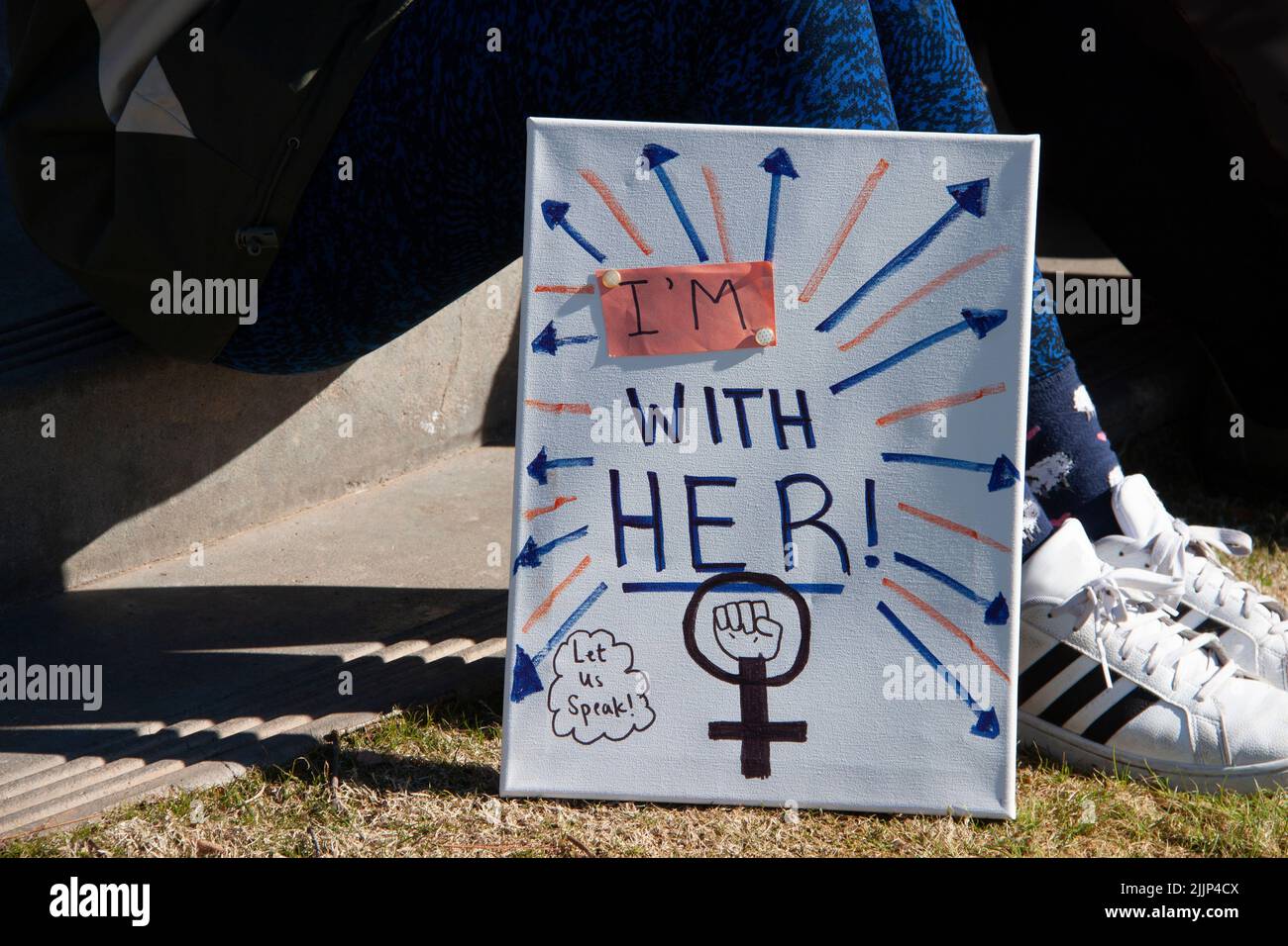 Sign painted on stretched cavas with sticky note attached saying I'm ...