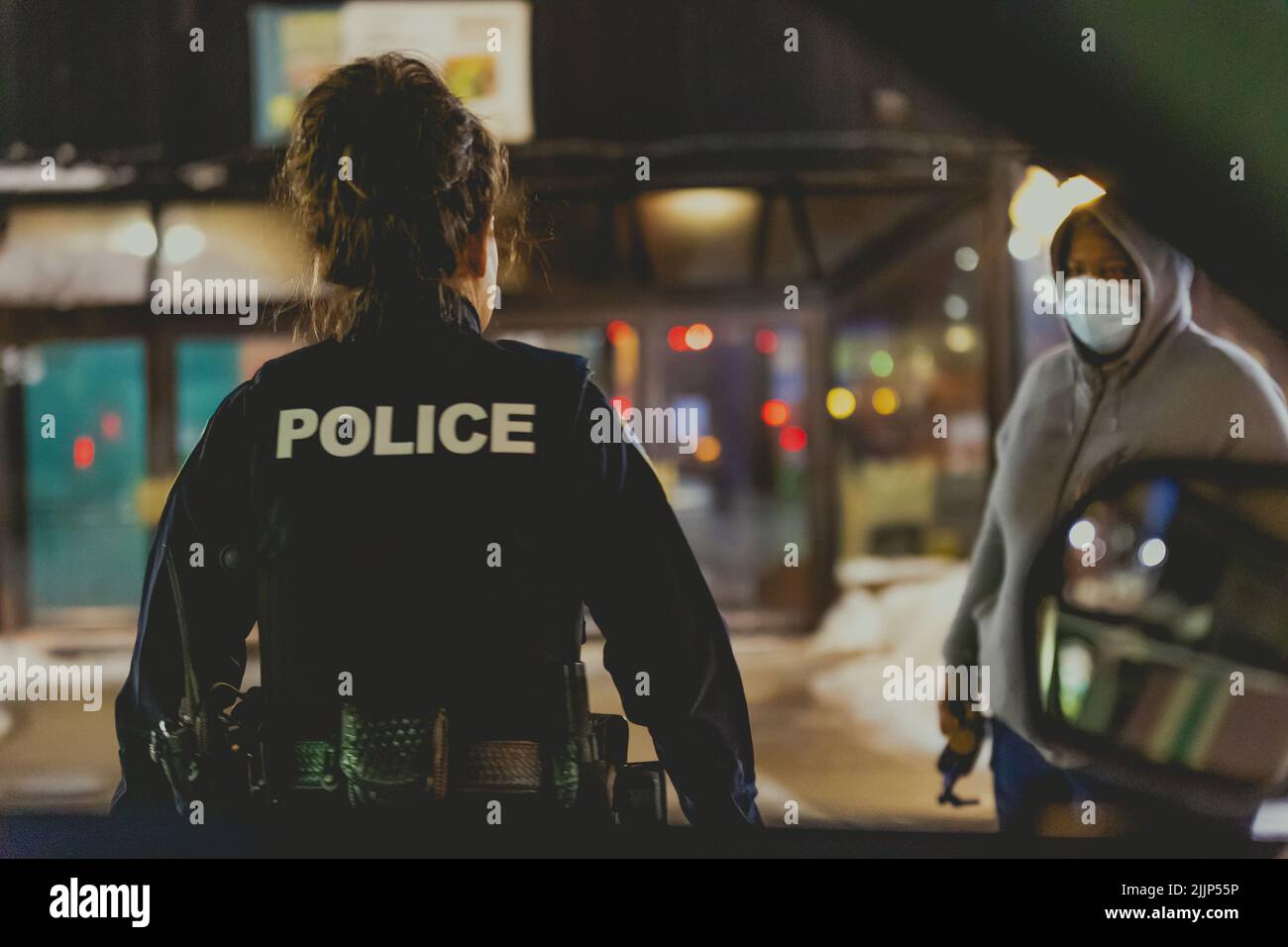 A female police officer approaching a witness of a local disturbance ...