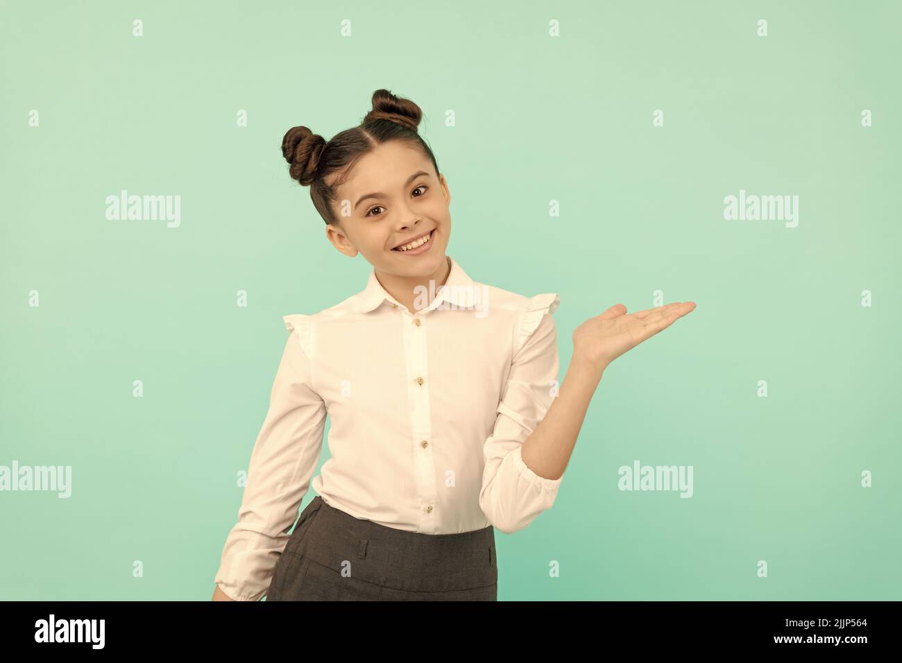 Happy school age child show open hand presenting product for copy space ...