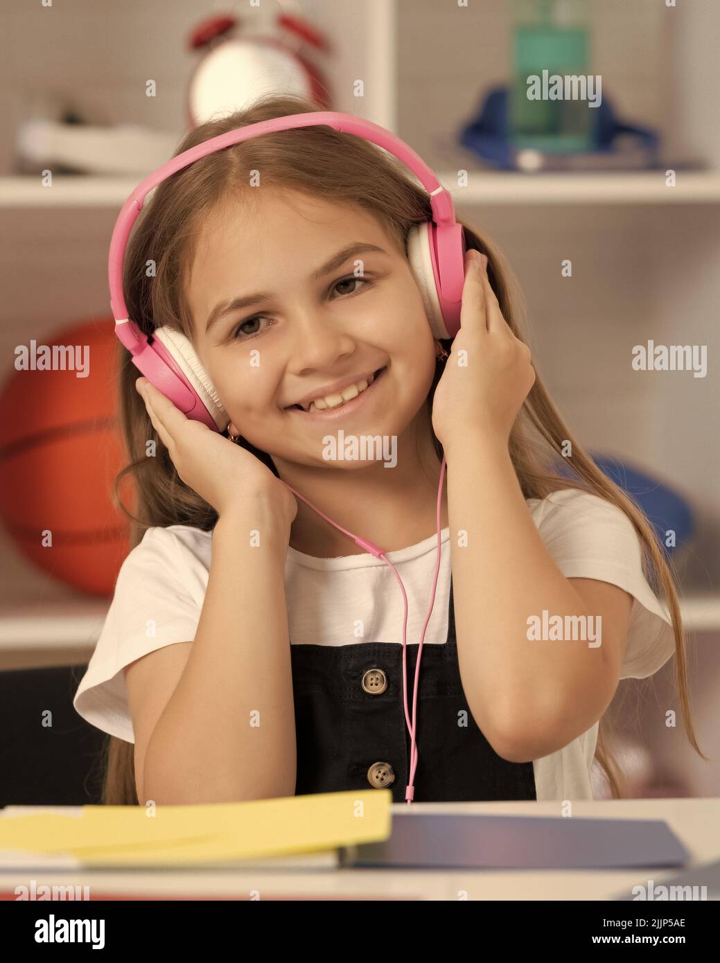 glad child listen to music in headphones at school classroom Stock ...