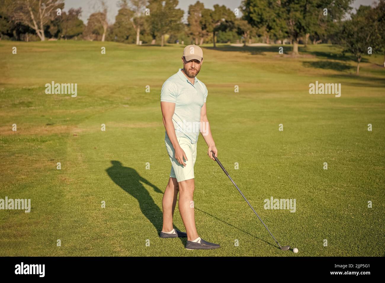 serious golfer in cap with golf club, golf player Stock Photo - Alamy