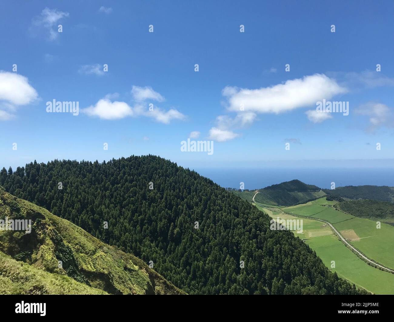 An aerial view of the green volcanic mountains and high hills with the ...