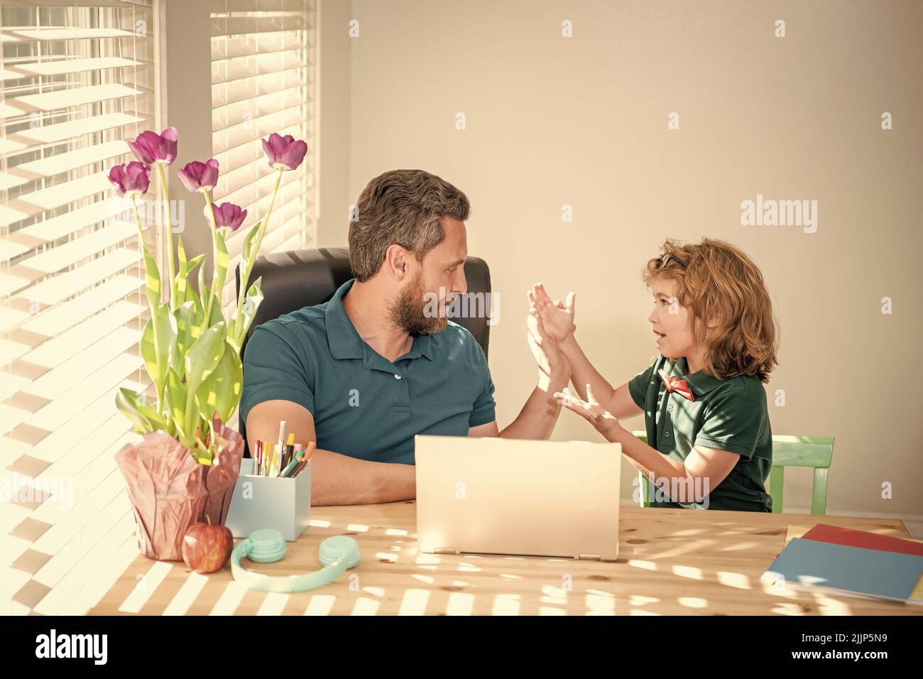 amazed father and child son at school working online on laptop ...