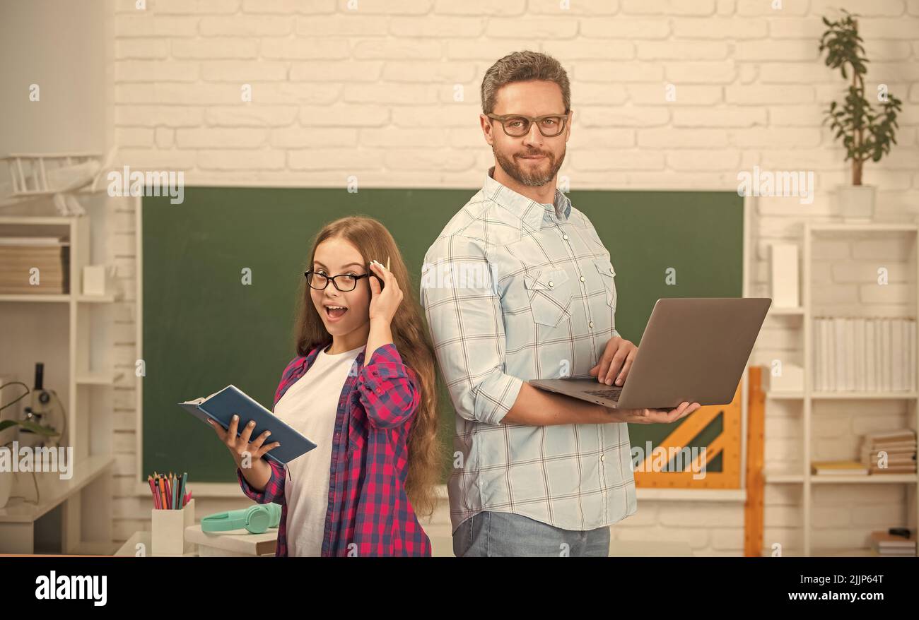 amazed teen girl and teacher man in high school with workbook at ...