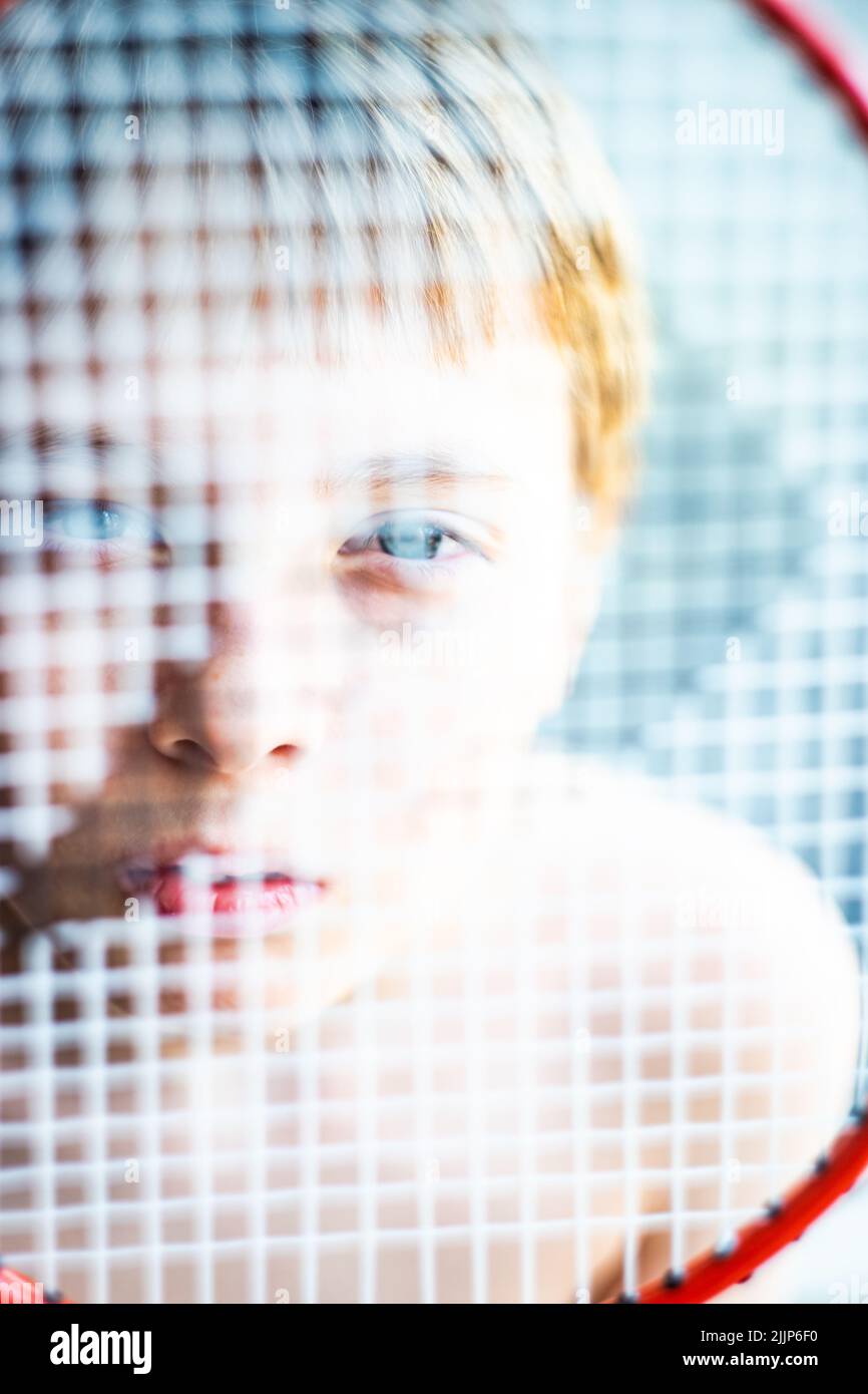 Boy holding a tennis racquet in front of his face Stock Photo - Alamy