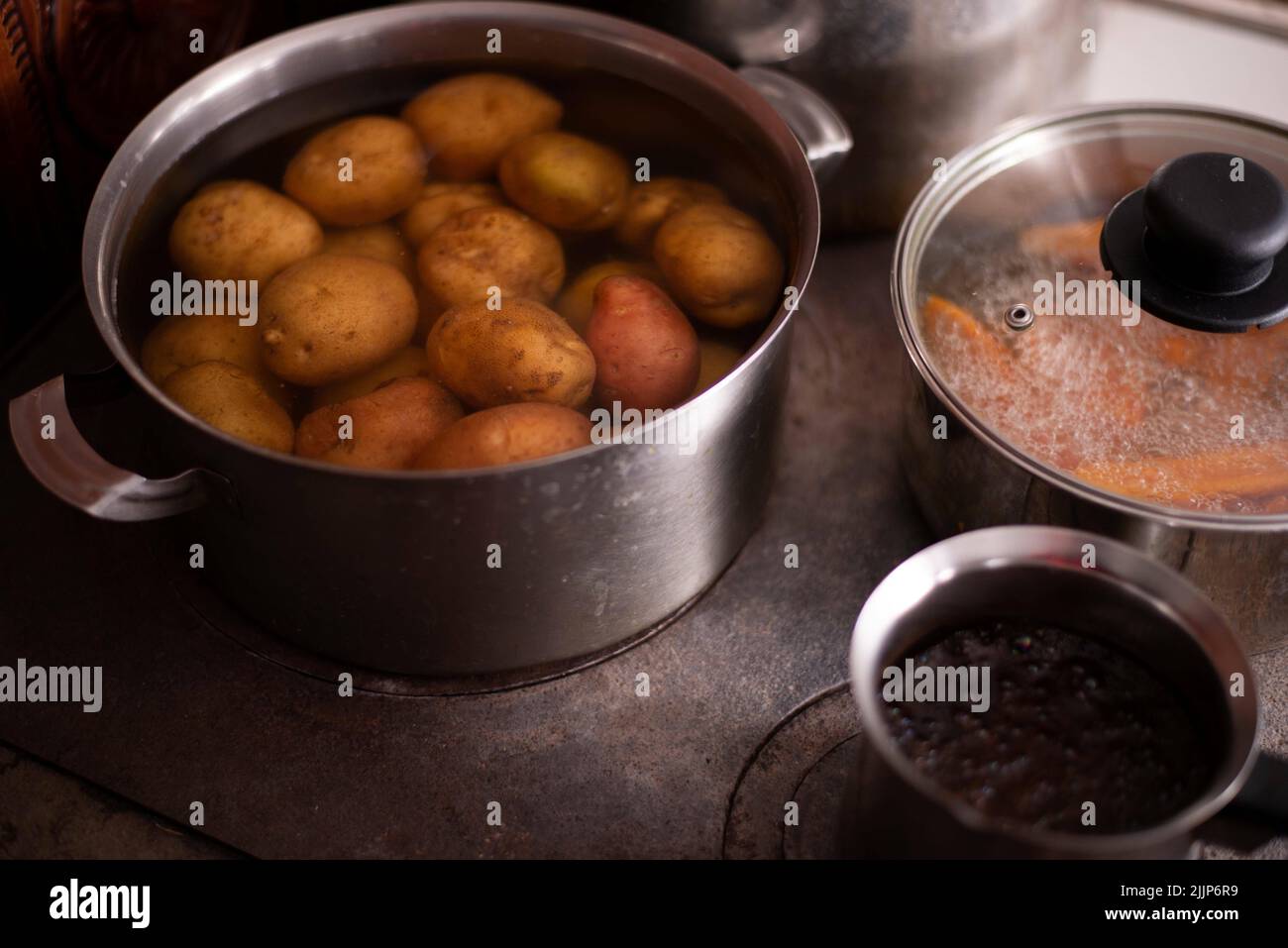 A closeup of potatoes in water ready to be boiled Stock Photo - Alamy