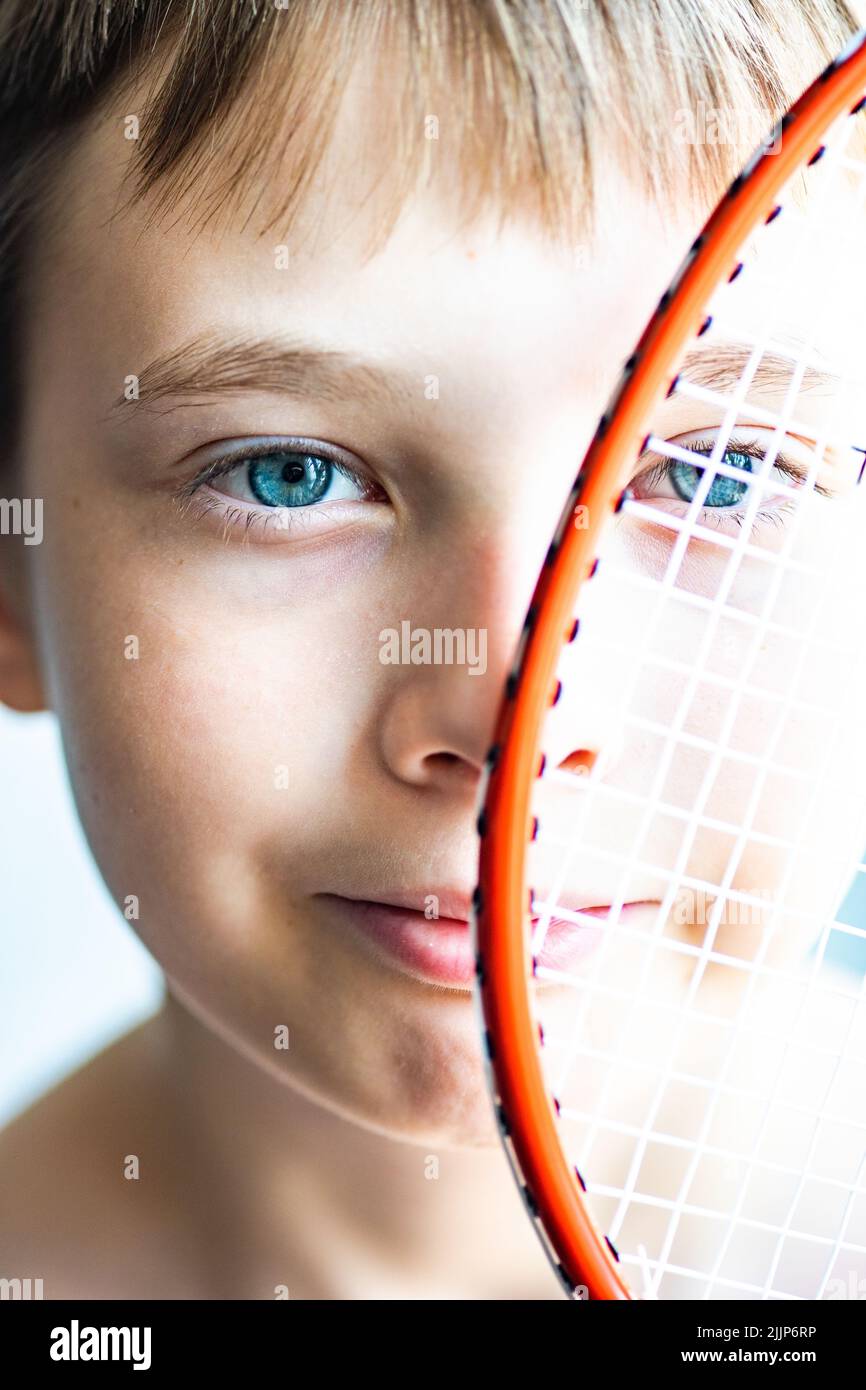 Boy holding a tennis racquet in front of his face Stock Photo - Alamy