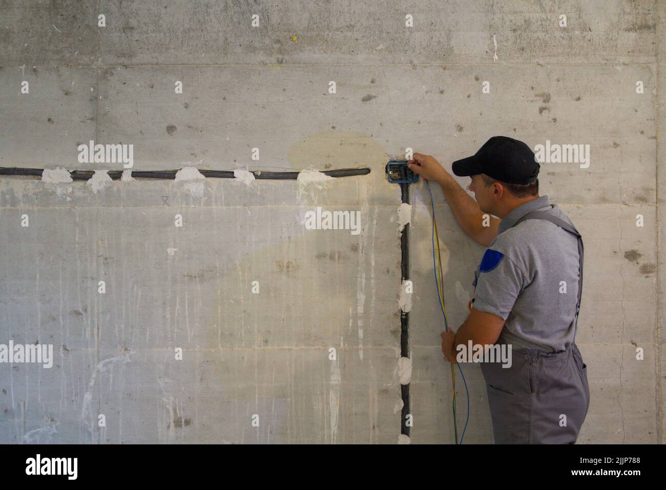 Image of a handyman electrician passing an electric probe through a ...