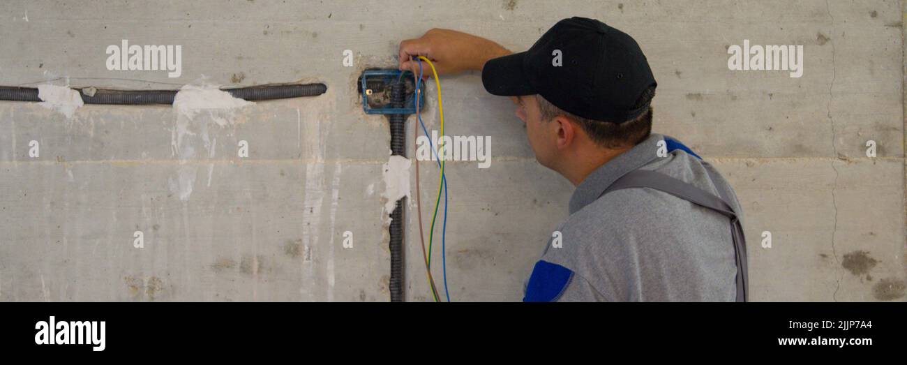 Image of a handyman electrician passing an electric probe through a ...