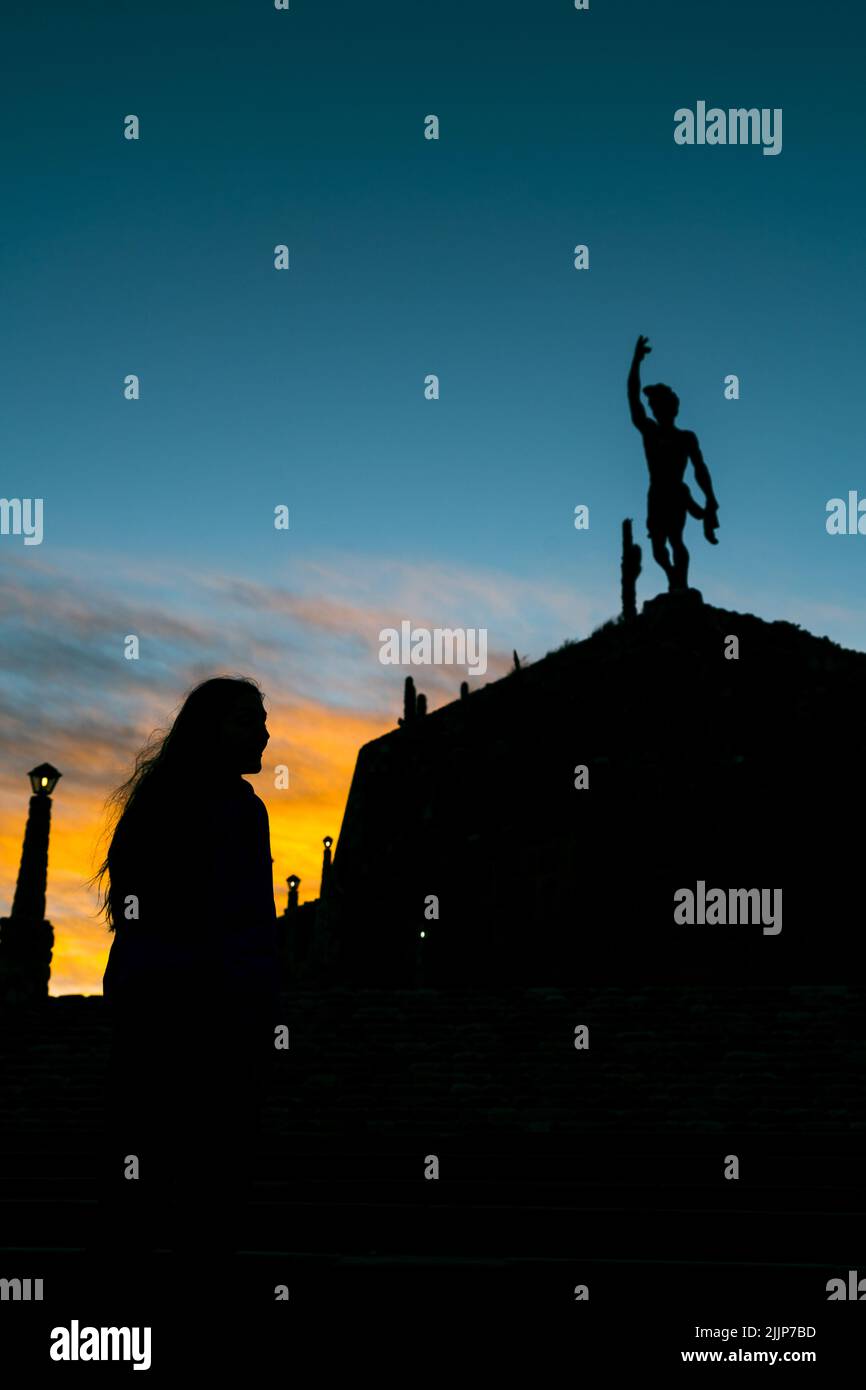 A silhouette of a female near the statue on the sunset Stock Photo - Alamy