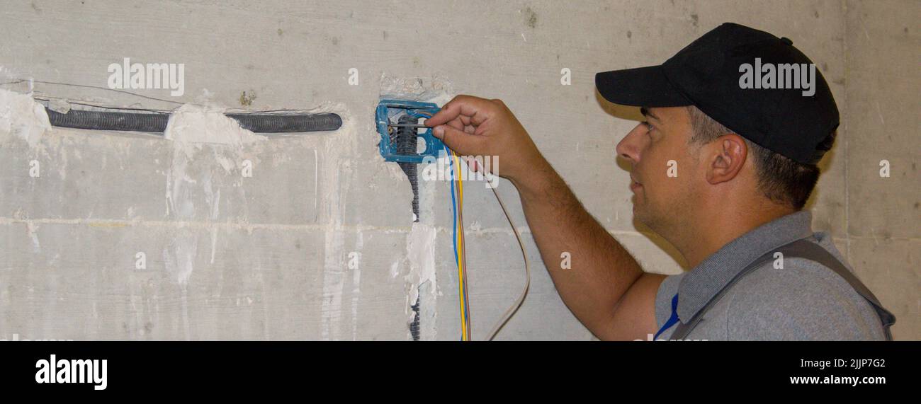Image of a handyman electrician passing an electric probe through a ...