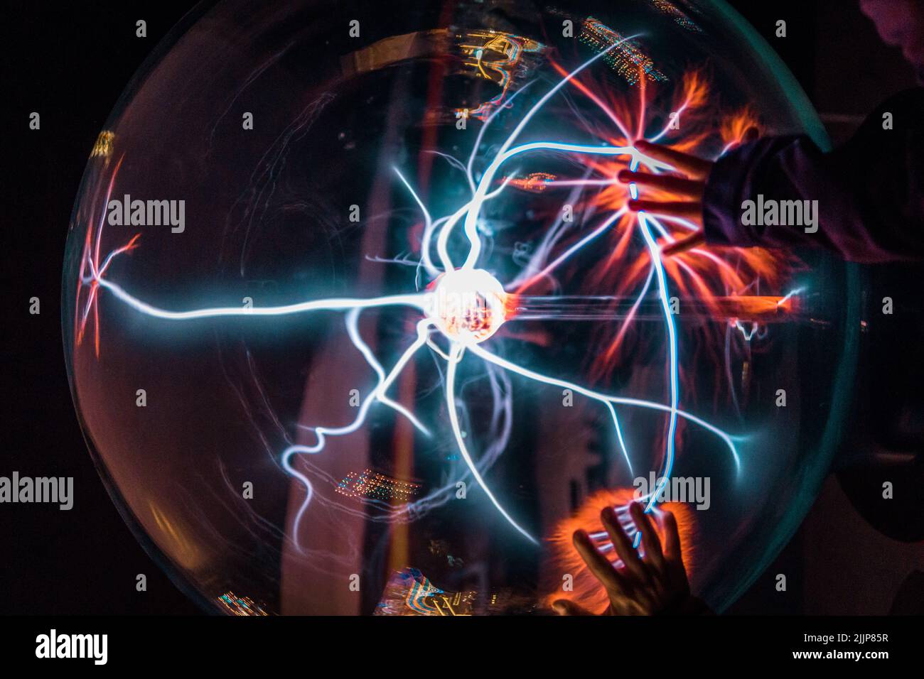 The hands of people touching a plasma ball Stock Photo - Alamy