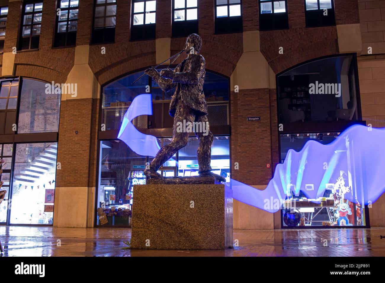 A statue playing music with a light rail behind it Stock Photo - Alamy