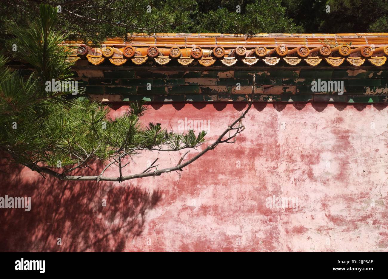 The exterior of the worn-out red painted wall of a palace in Beijing ...