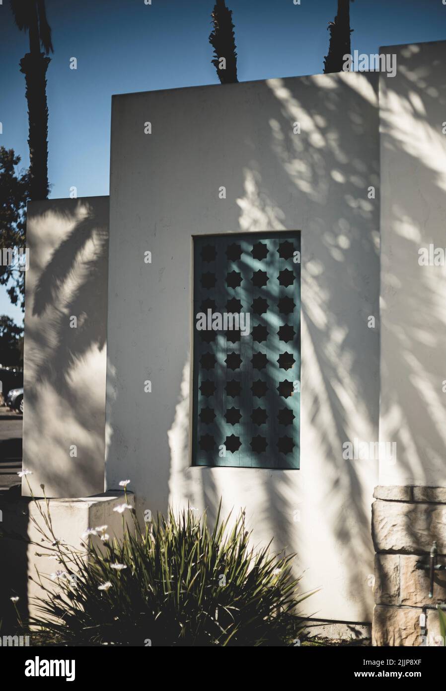 A patterned window in a building with tree shadows Stock Photo - Alamy