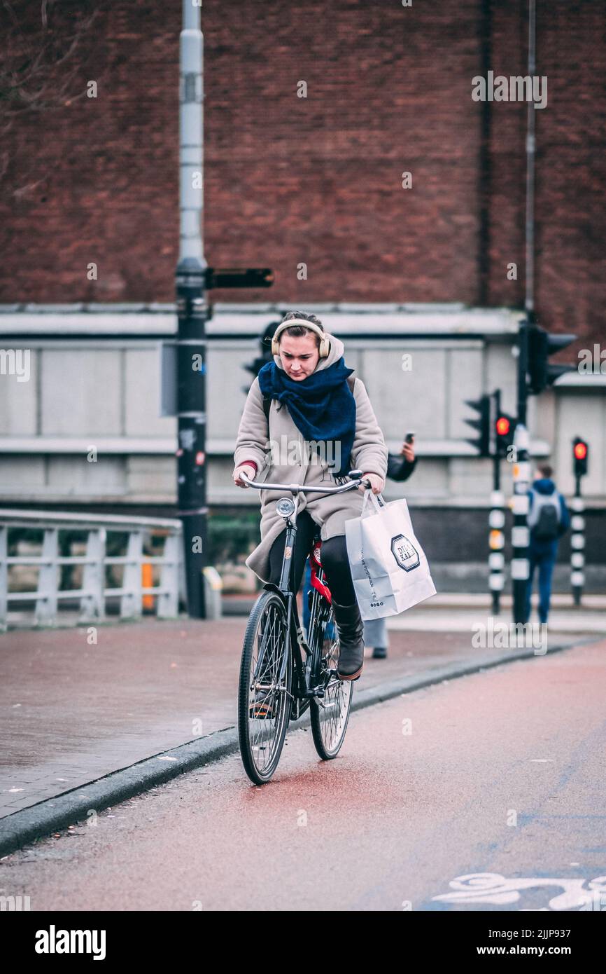 A woman on bike in Amsterdam riding across the road Stock Photo - Alamy