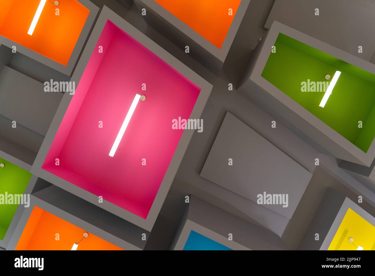 An interior view of a colorful ceiling of a modern building with lights ...