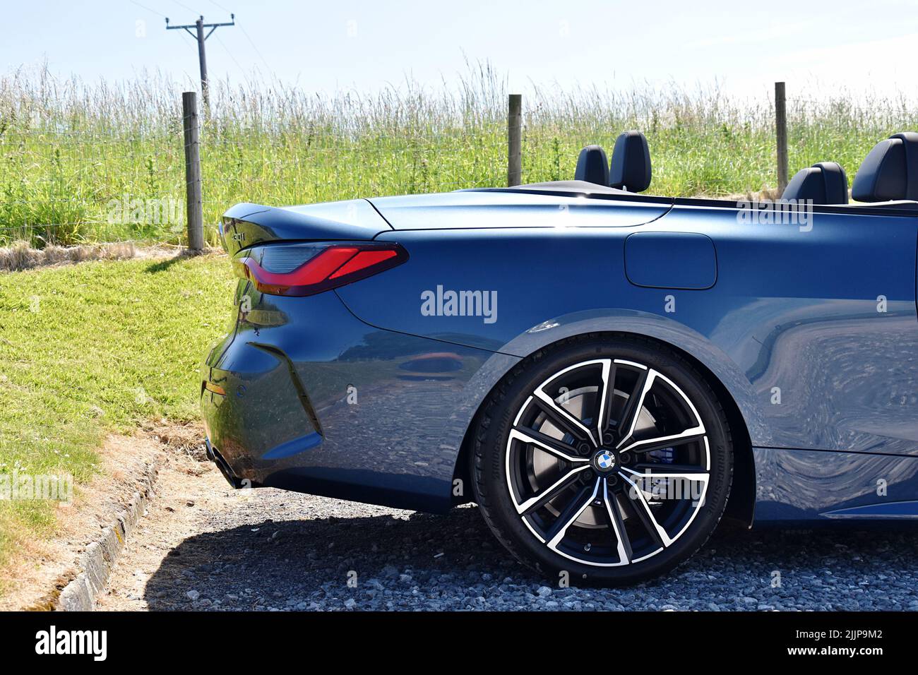 A rear side view of a modern luxury convertible car on the field ...
