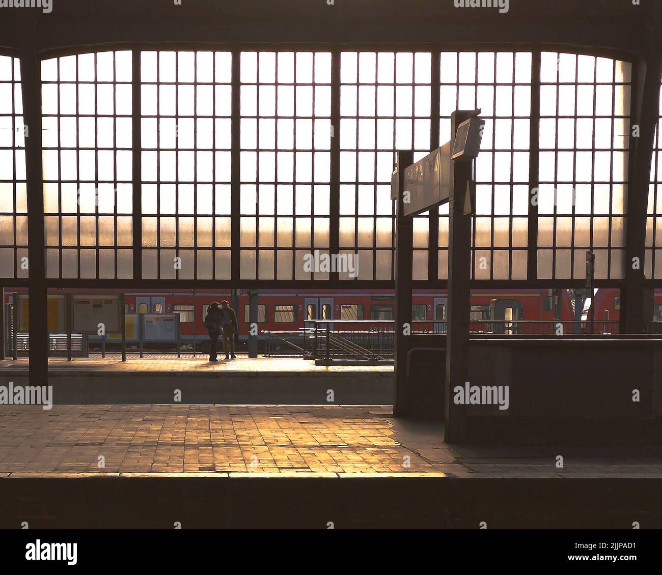 A large, light-flooded train station where people say goodbye captured ...