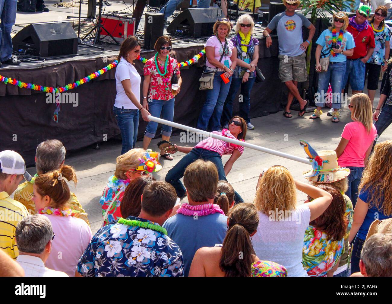 Woman holding her shoes and bending over backwards to dance under a ...