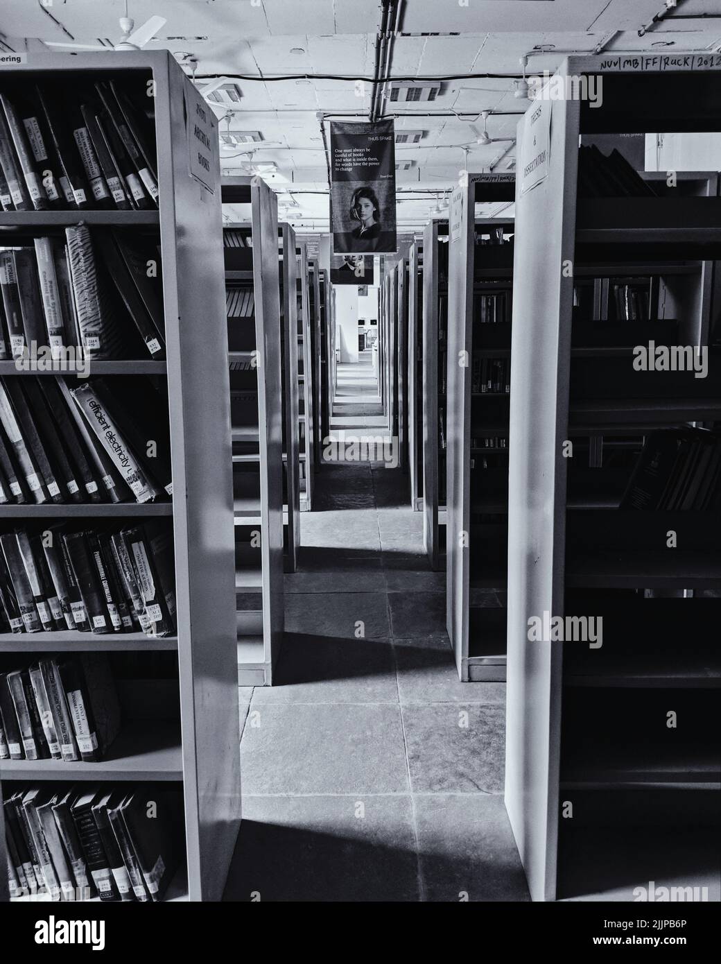 A grayscale shot of the library with books on the rack Stock Photo - Alamy