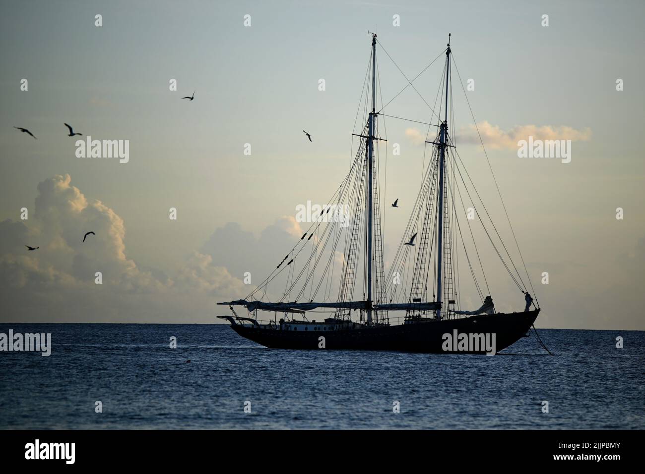 A beautiful scene of a high sailboat in the sea water against a gray ...