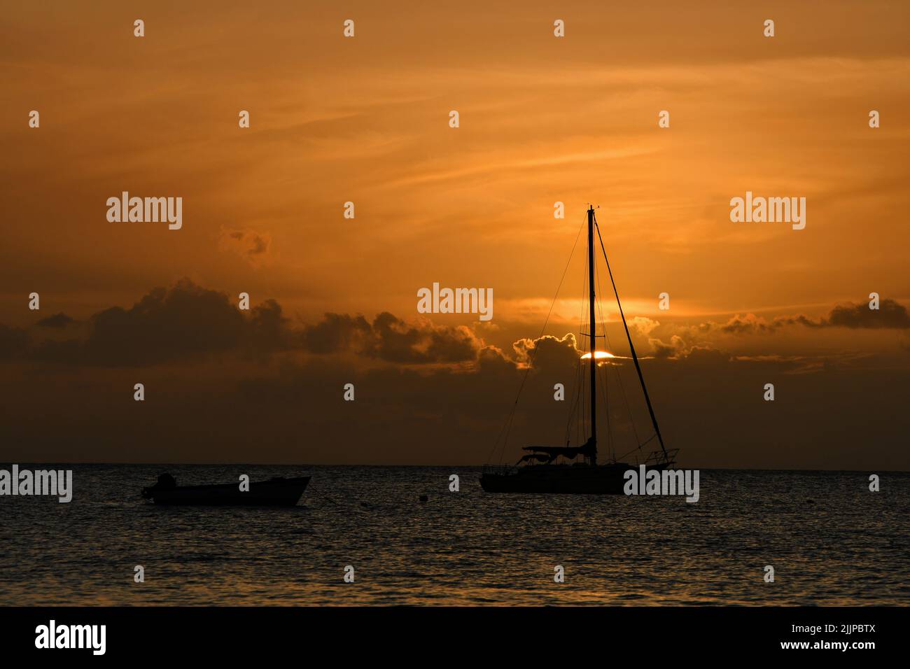A closeup of boats in a sea with an orange cloudy sky background Stock ...