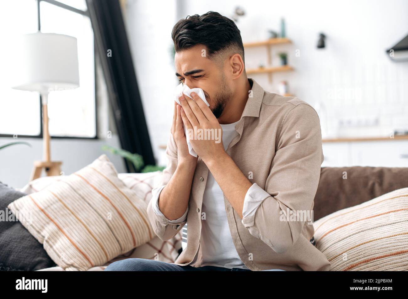 The concept of illness, runny nose. Unhealthy sad arabian or indian man ...