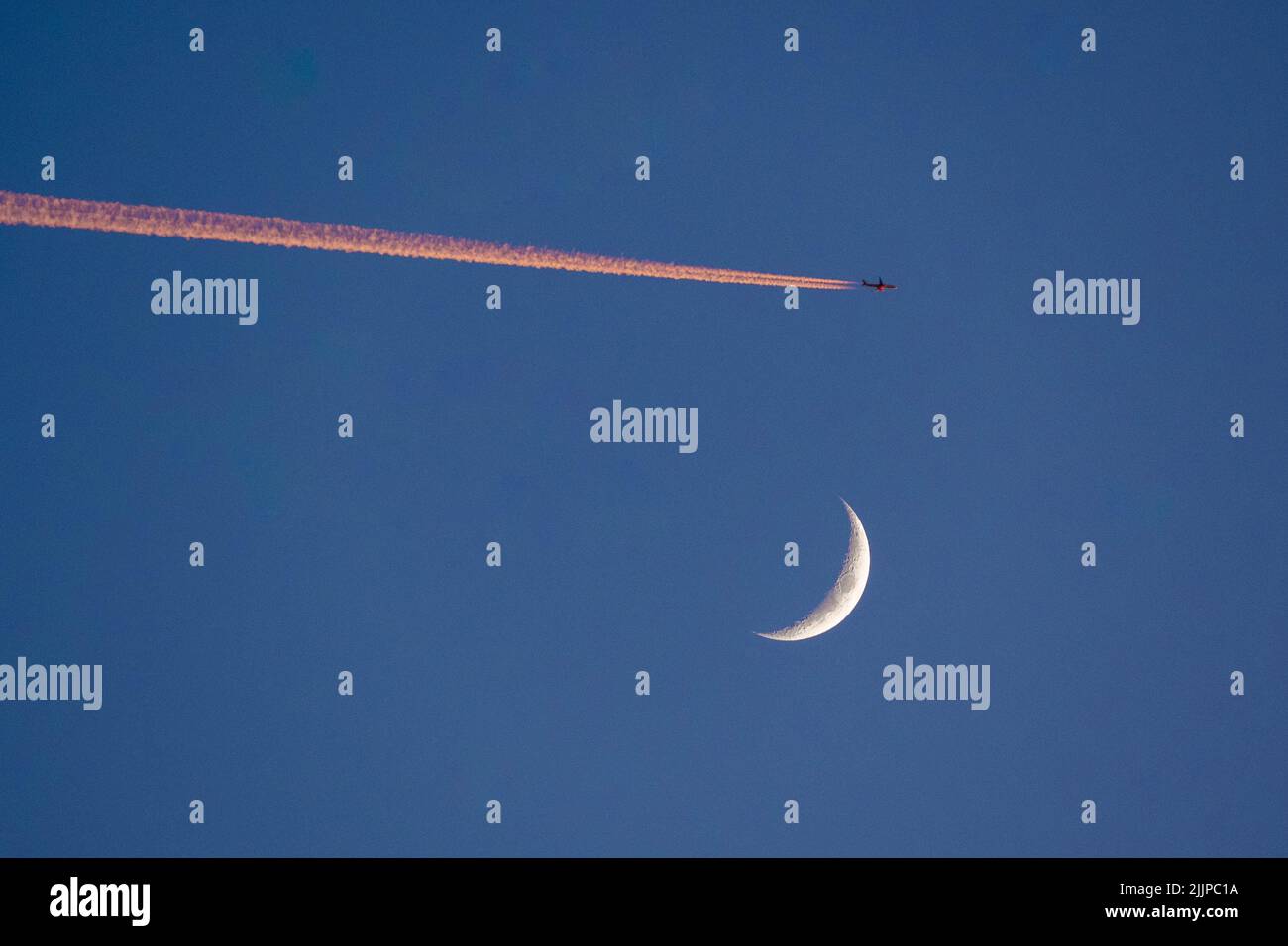 A scenery of an airplane flying in the blue sky above the moon Stock ...