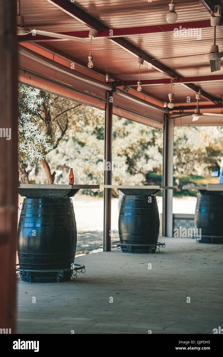A closeup of Barrel stands outside a bar under a roof Stock Photo - Alamy